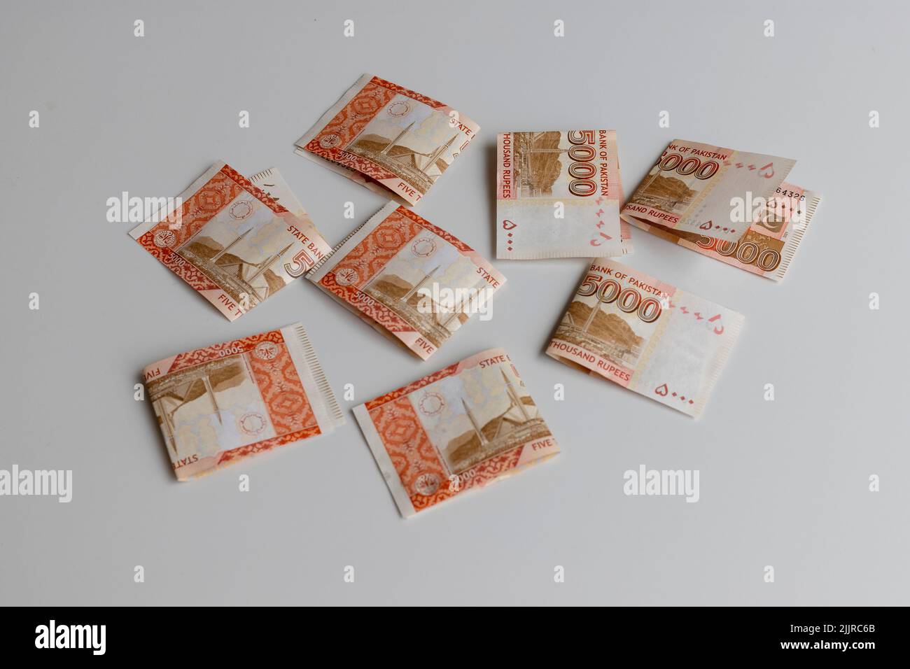 Five thousand currency notes folded on a white background Stock Photo ...