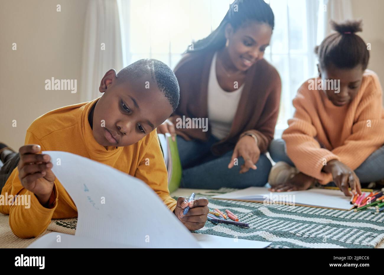 Will you help me mom. a young boy completing his school work at home ...