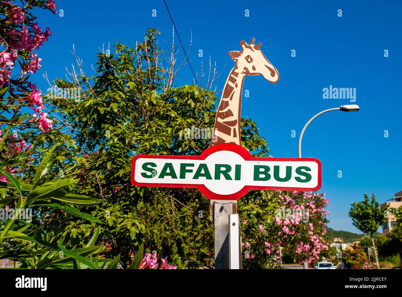 A safari bus zoo giraffe sign on blue sky background in Majorca, Spain ...