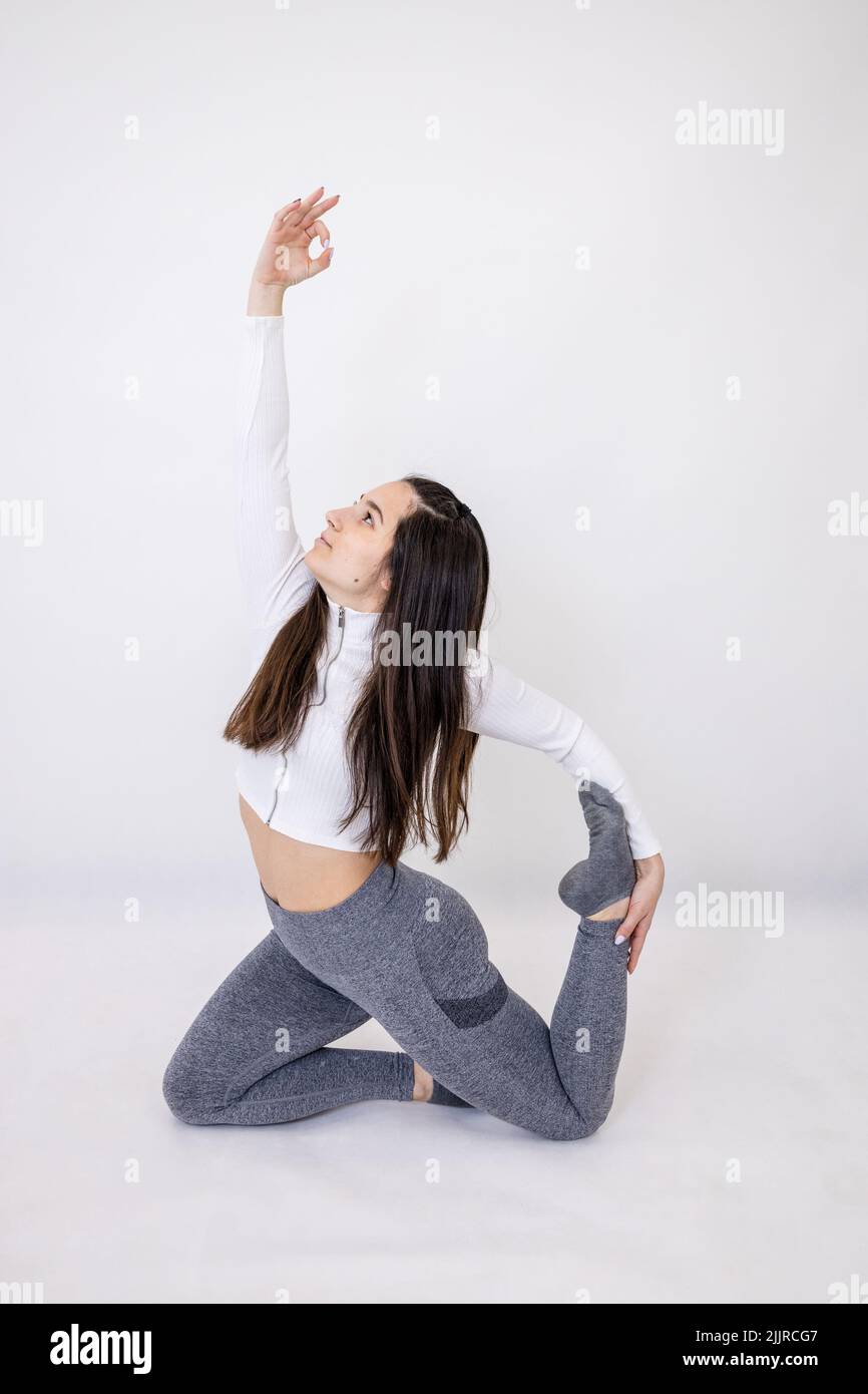 A vertical shot of female yoga teacher doing performing intensive ...
