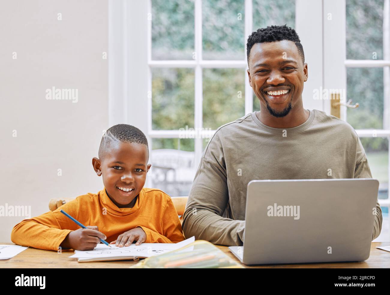 Weve both got work to do. a young father using a laptop while his son ...