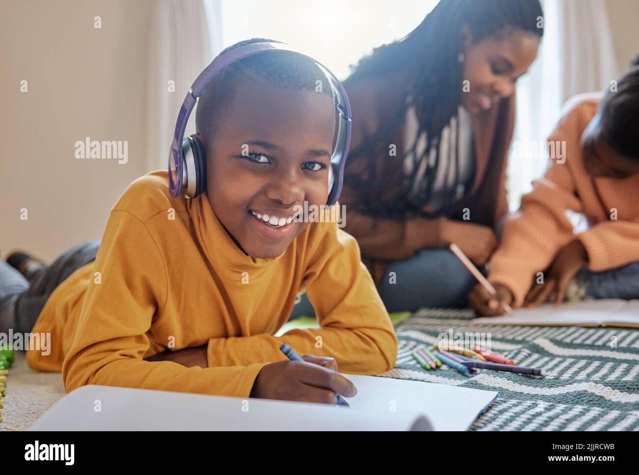 Music makes the work easier. a young boy completing school work while ...