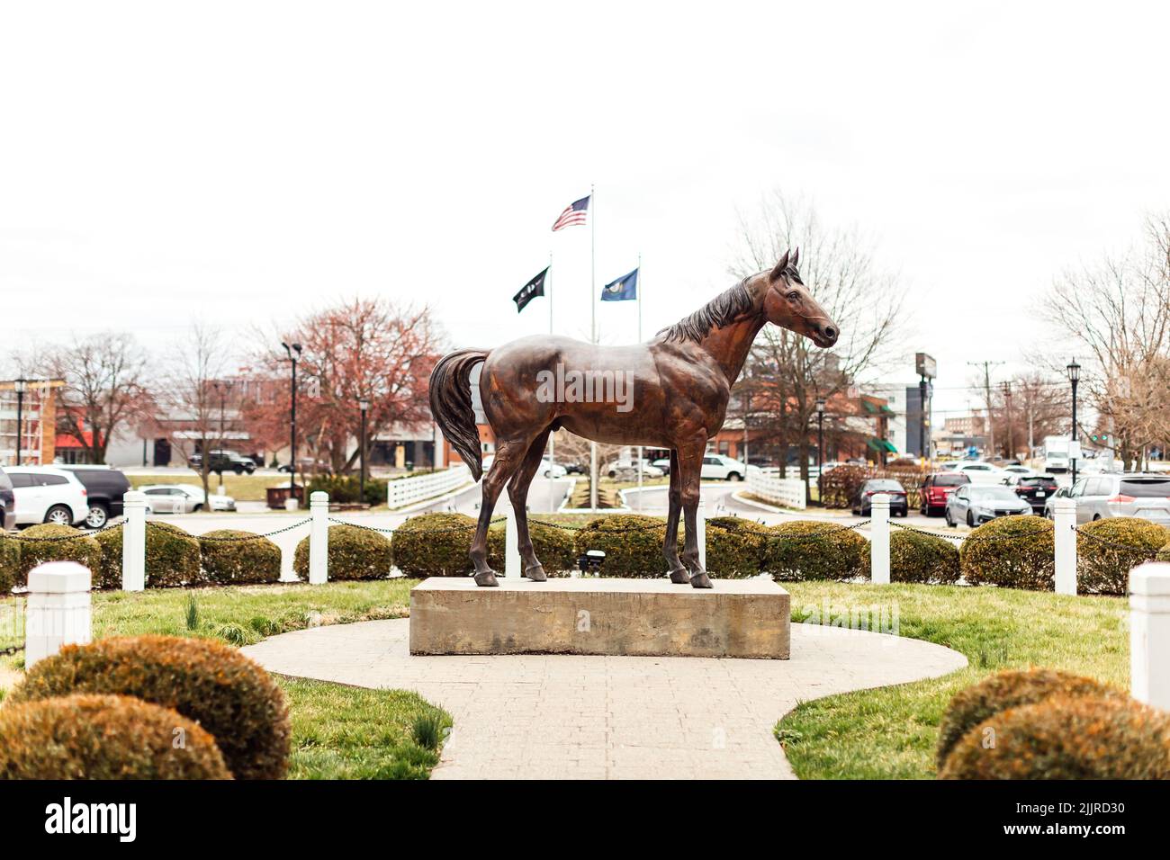 A horse statue on a stand with flags in the background Stock Photo - Alamy