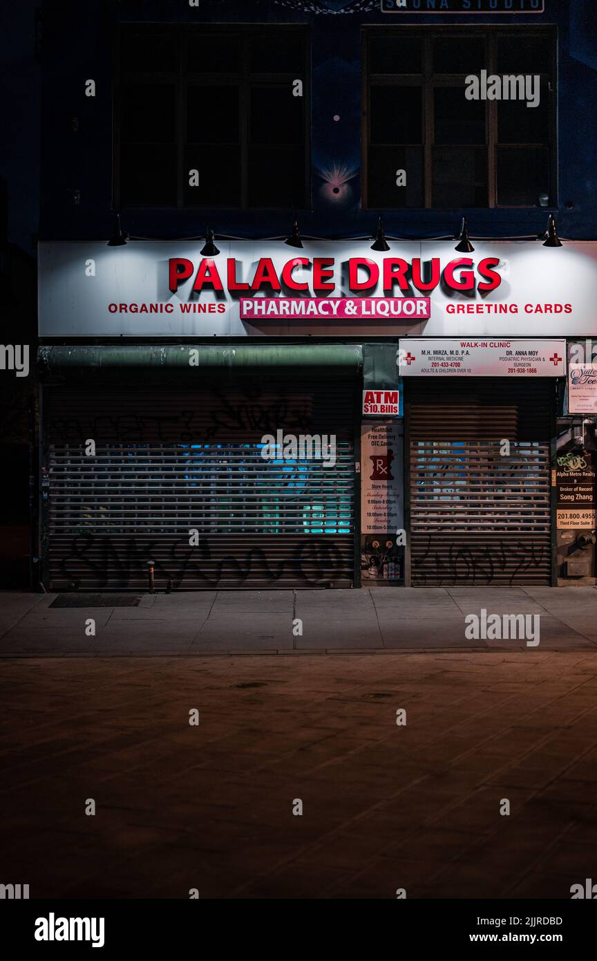 A front view of closed street shops with signs at night Stock Photo - Alamy