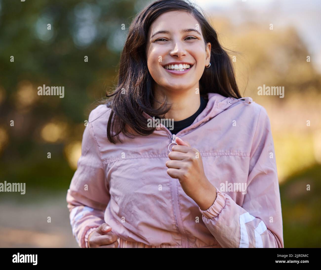 Getting my daily workout in. an attractive young woman jogging alone ...