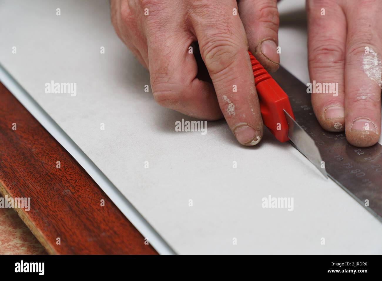 A man cuts a plastic pvc panel with a construction knife Stock Photo ...