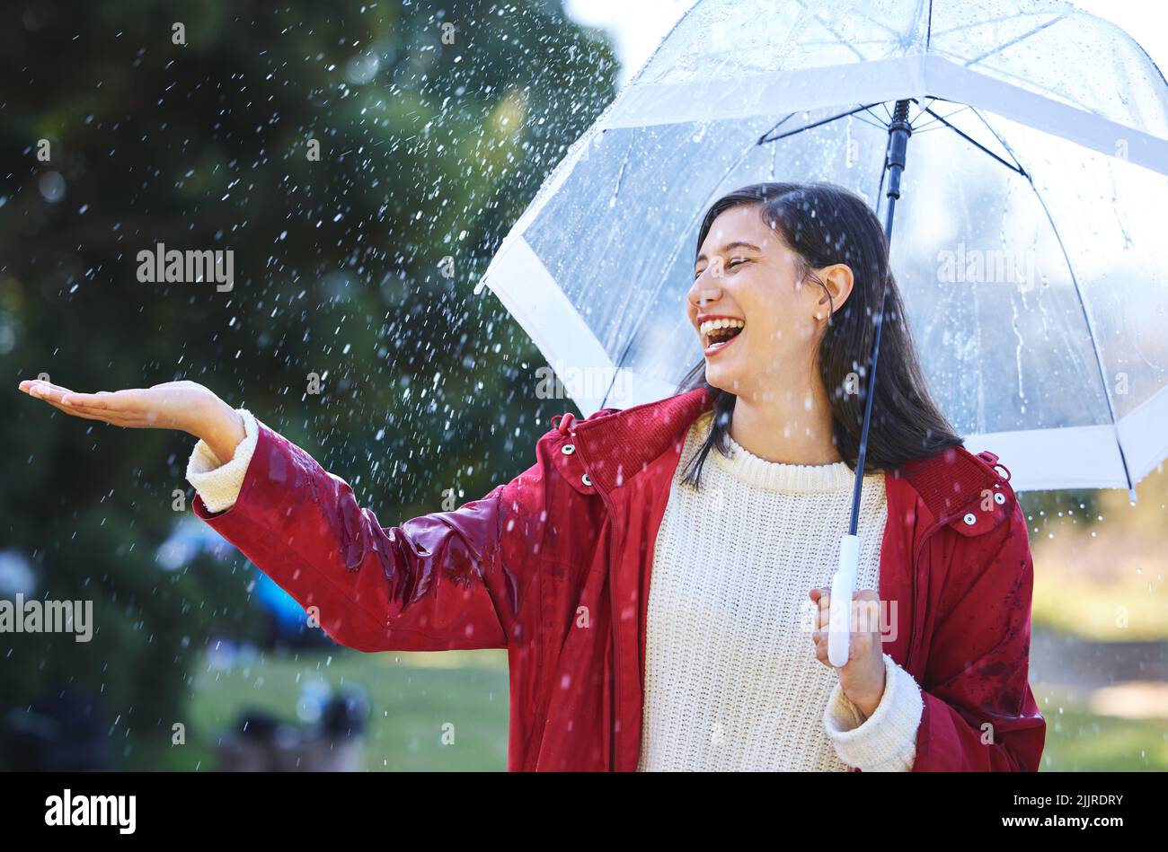 I love the feeling of rain on my skin. a young woman standing in the ...