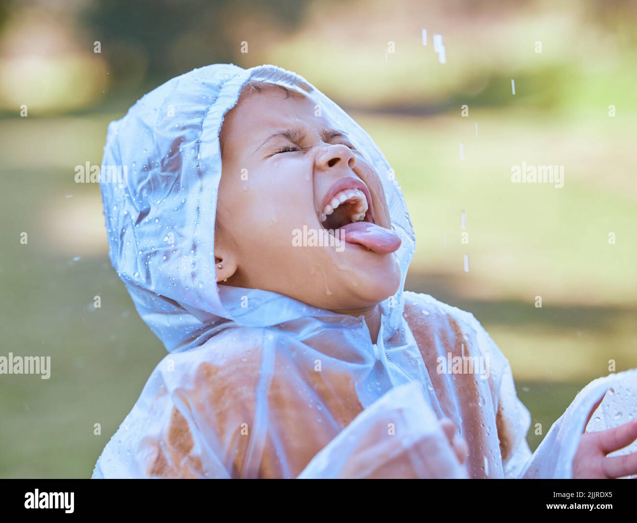I wonder what rain tastes like. a little girl sticking her tongue out ...