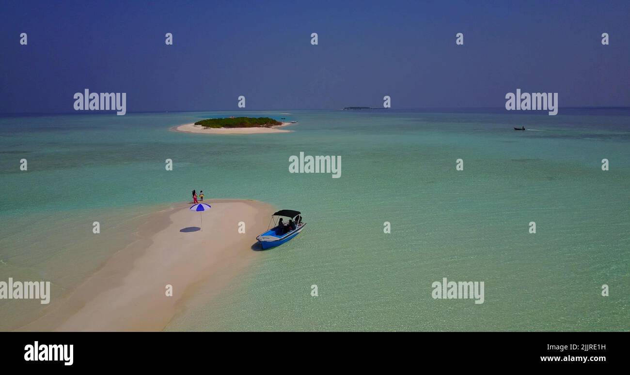 An aerial view of sea with people standing on sandy beach and floating ...