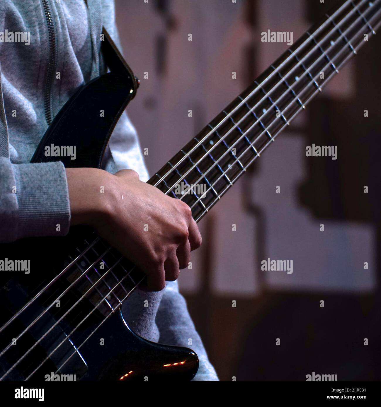 Bass guitar in the hands of a guitarist. Soft focus Stock Photo - Alamy