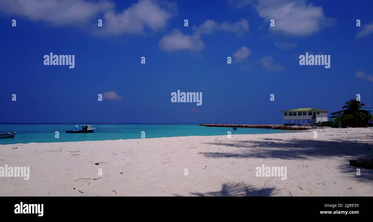 An aerial view of sandy beach in background of boat floating on sea in ...