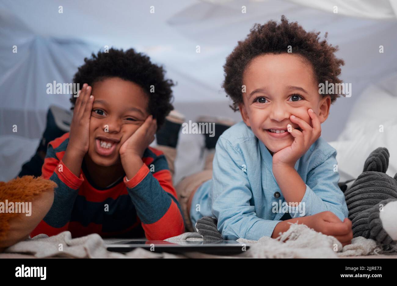 Can you make a funny face. two little brothers using a digital tablet ...