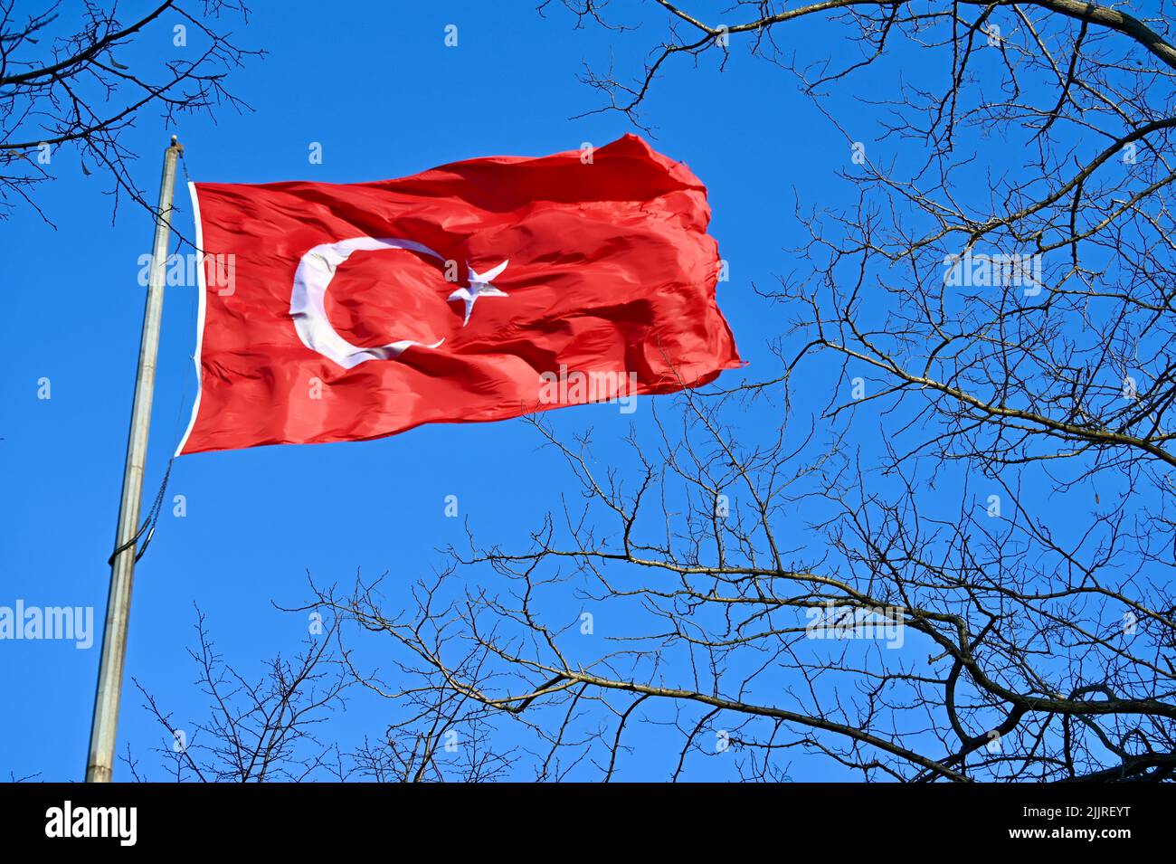 The flag of Turkey waving on a blue sky background Stock Photo - Alamy