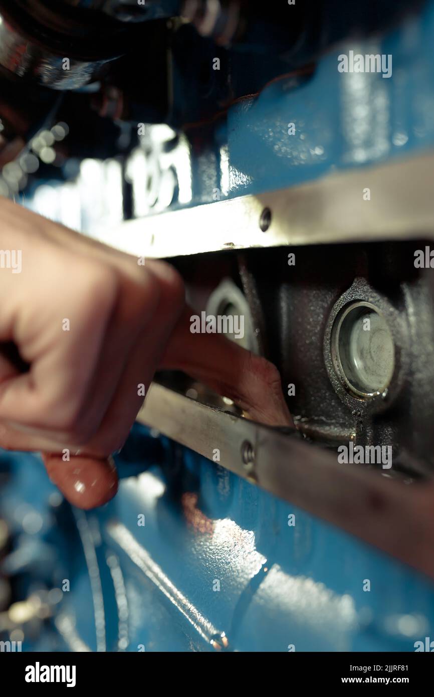 A vertical closeup shot of a mechanic mounting the car engine Stock ...