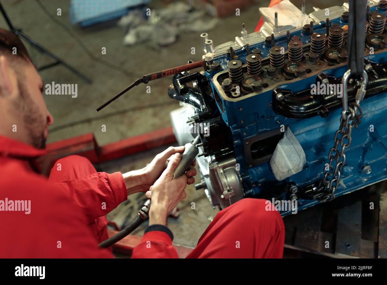 A high angle shot of a mechanic mounting the C engine with special ...