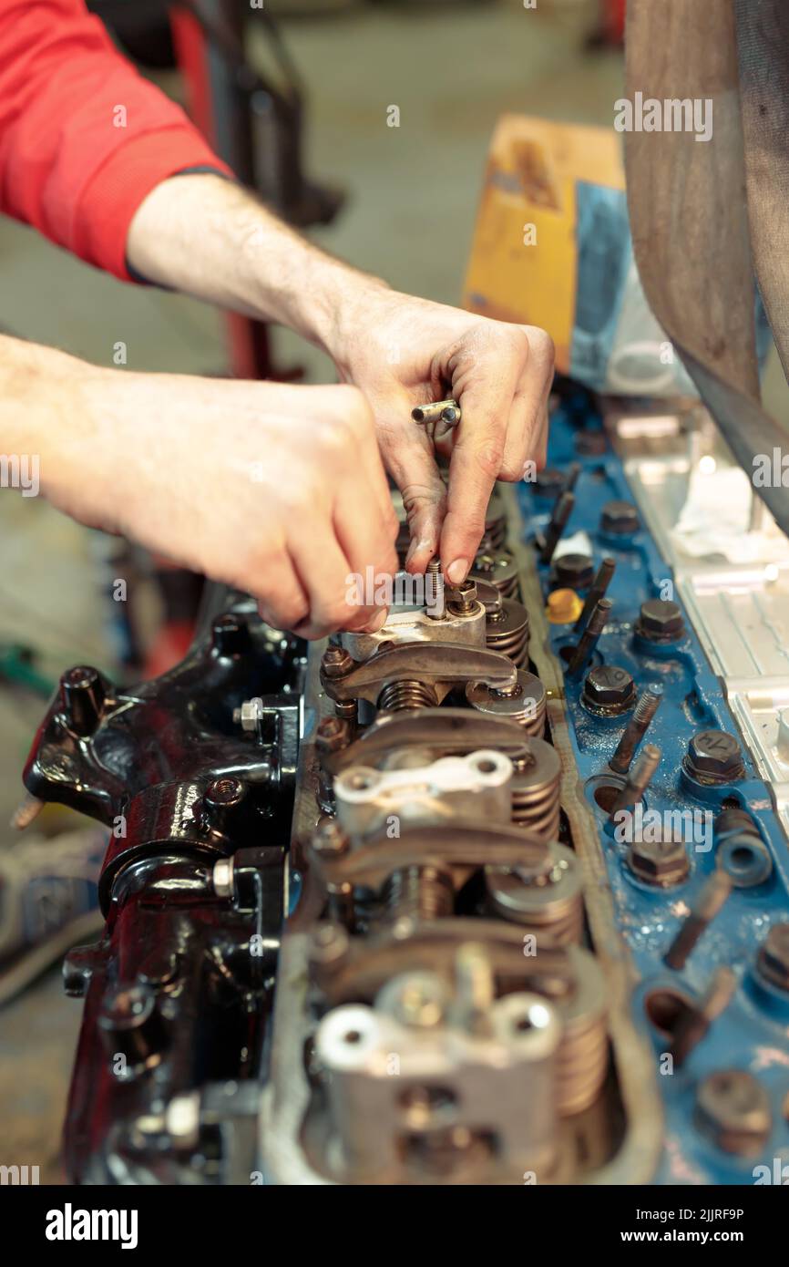 A vertical closeup shot of a mechanic mounting the car engine Stock ...