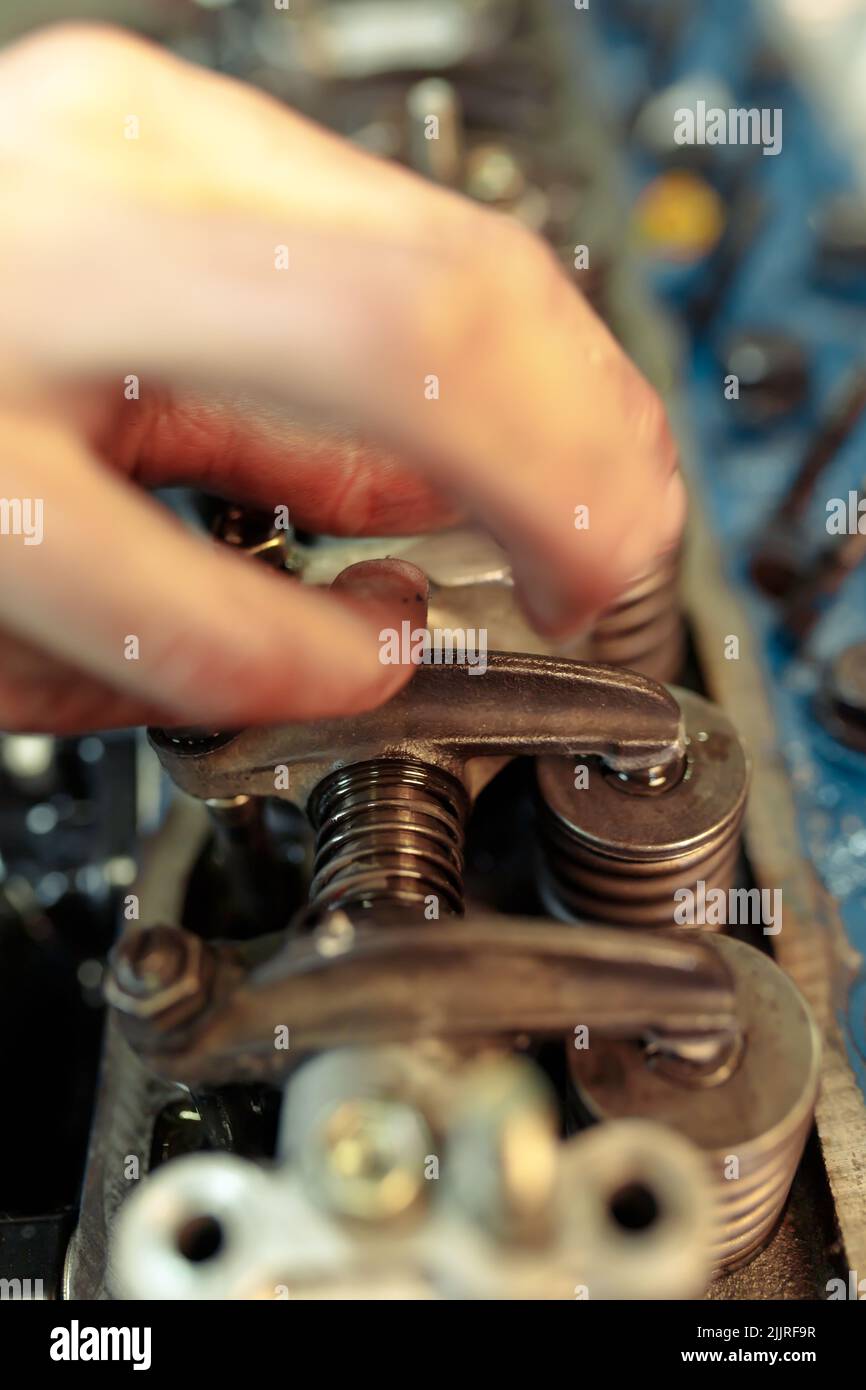 A vertical closeup shot of a mechanic mounting the car engine Stock ...