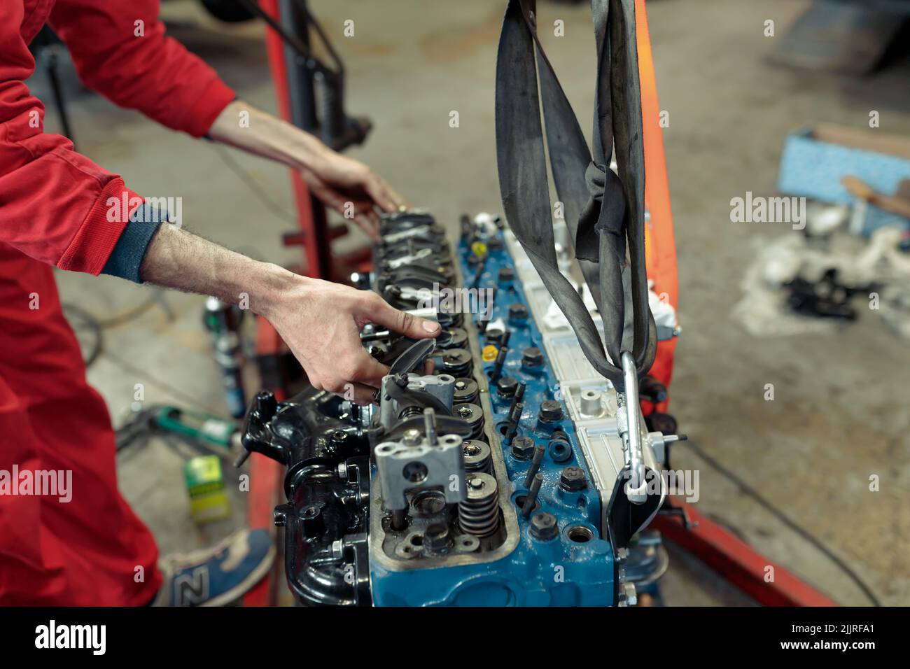 A young Caucasian mechanic mounting the car engine Stock Photo - Alamy