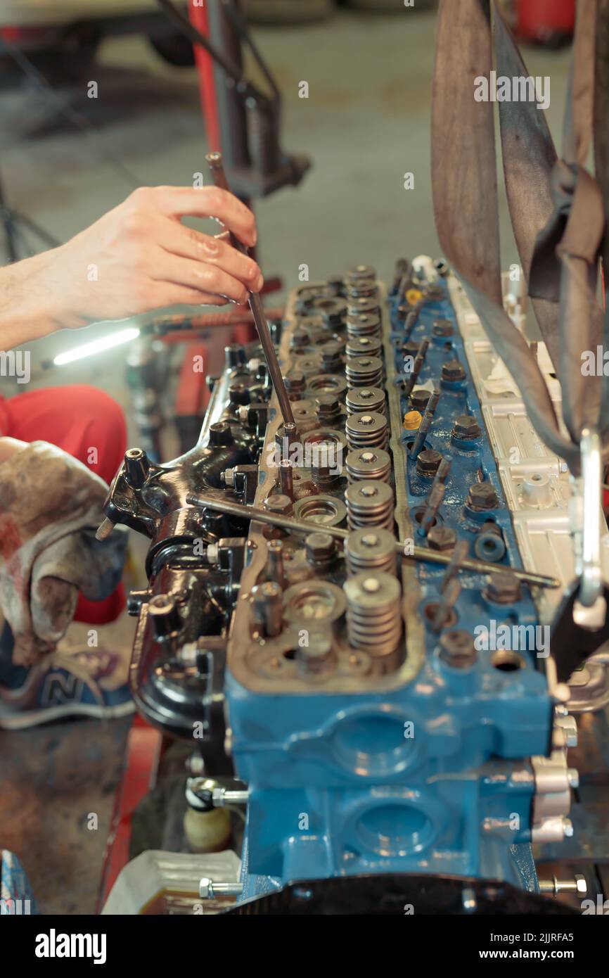 A vertical closeup shot of a car mechanic repairing the engine Stock ...