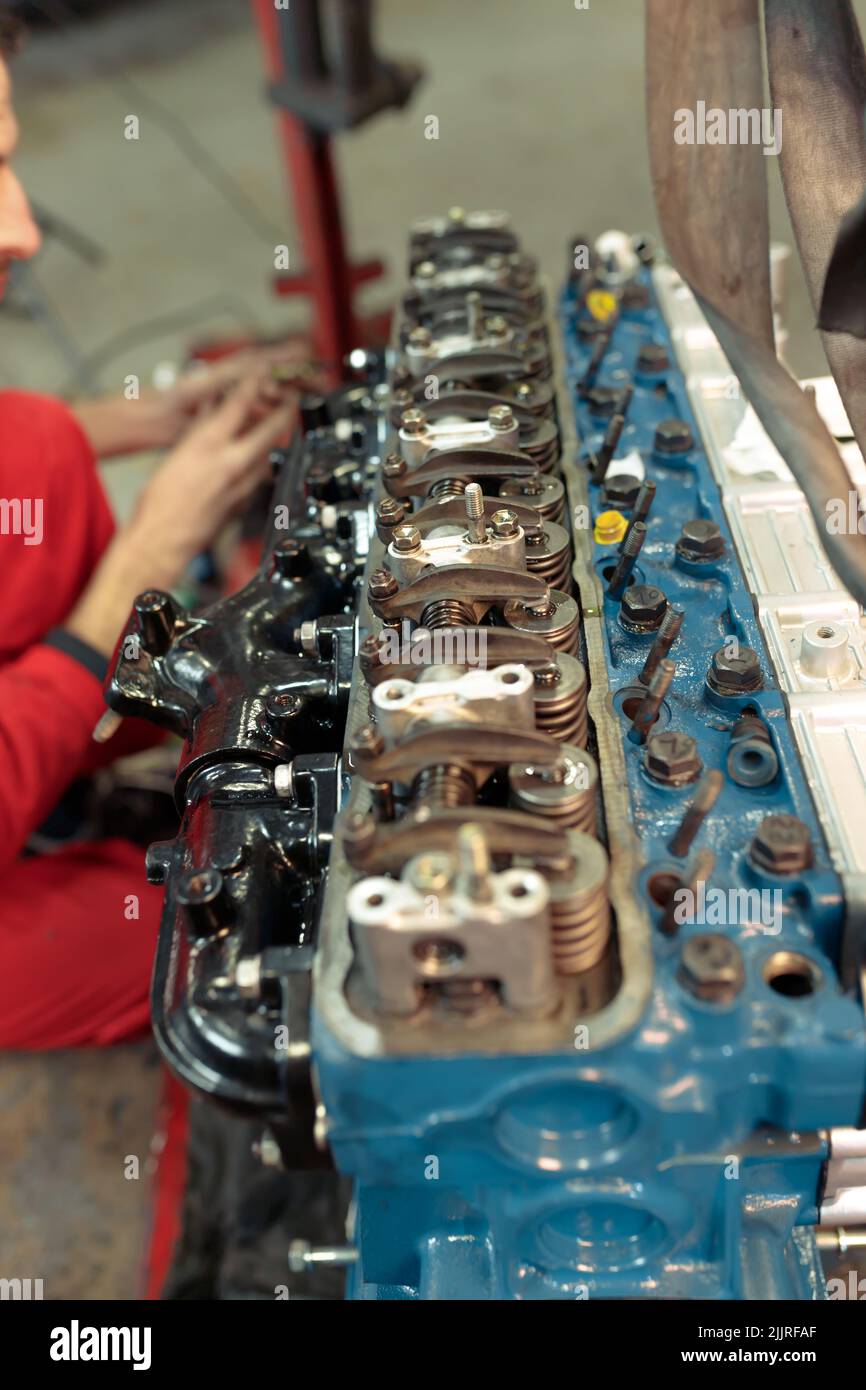A vertical closeup shot of a mechanic mounting the car engine Stock ...