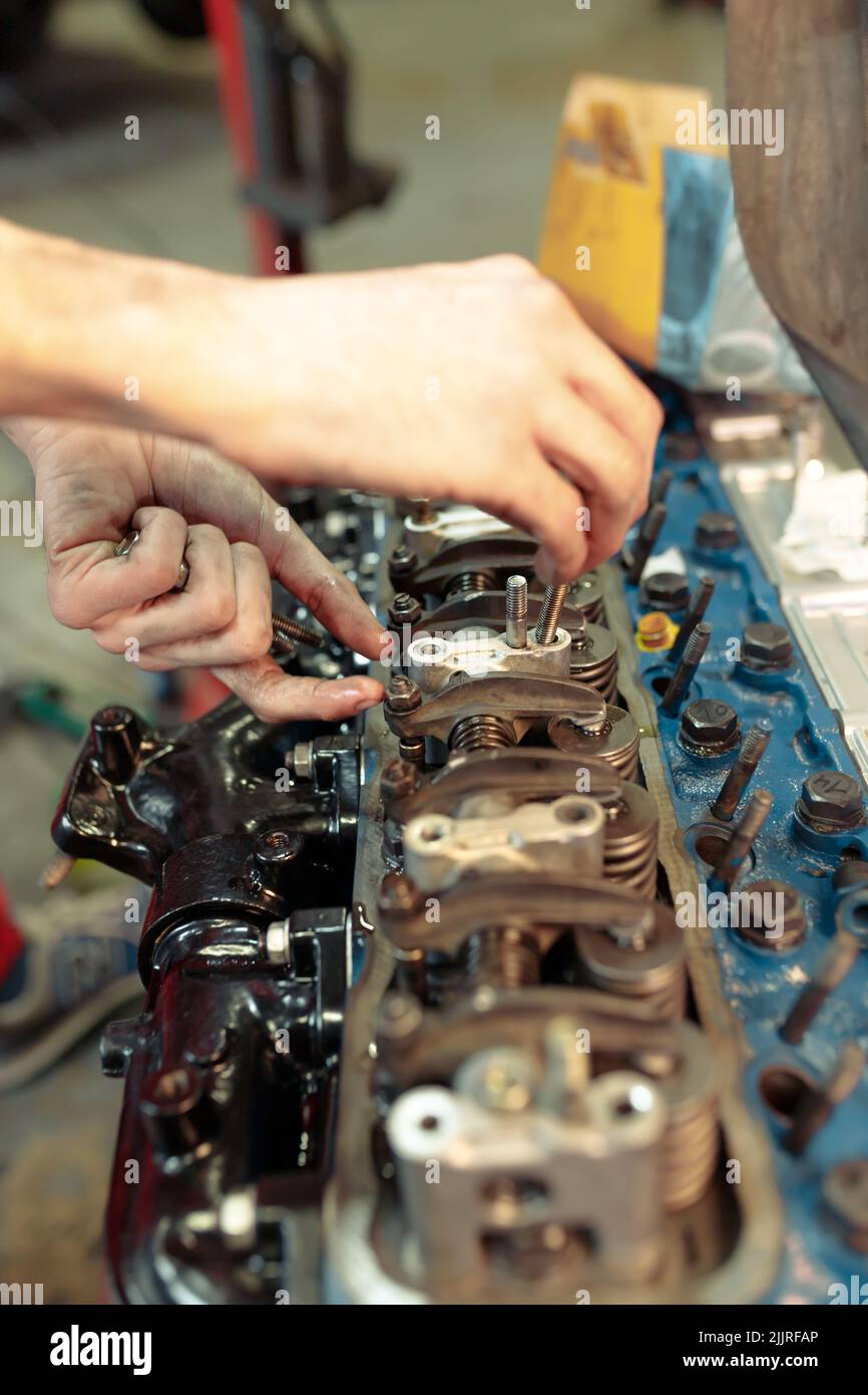 A vertical closeup shot of a mechanic mounting the car engine Stock ...