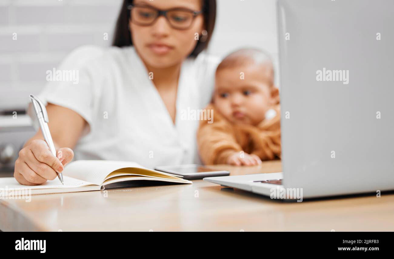 Ive got to make a note of that. a young mother writing in a notebook ...