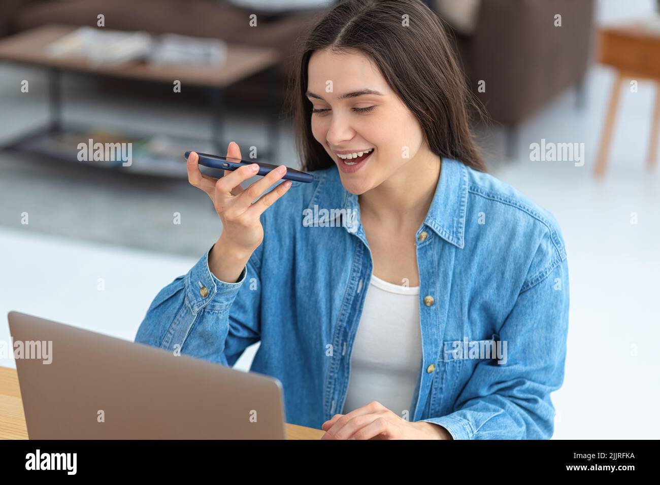 Young woman freelancer or office employee talking on mobile phone ...