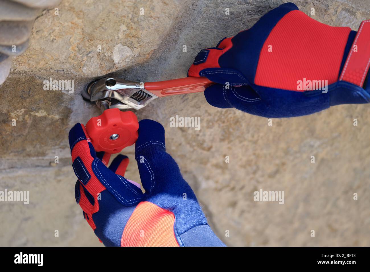 Male hands in work gloves repairing tap outside using wrench Stock ...
