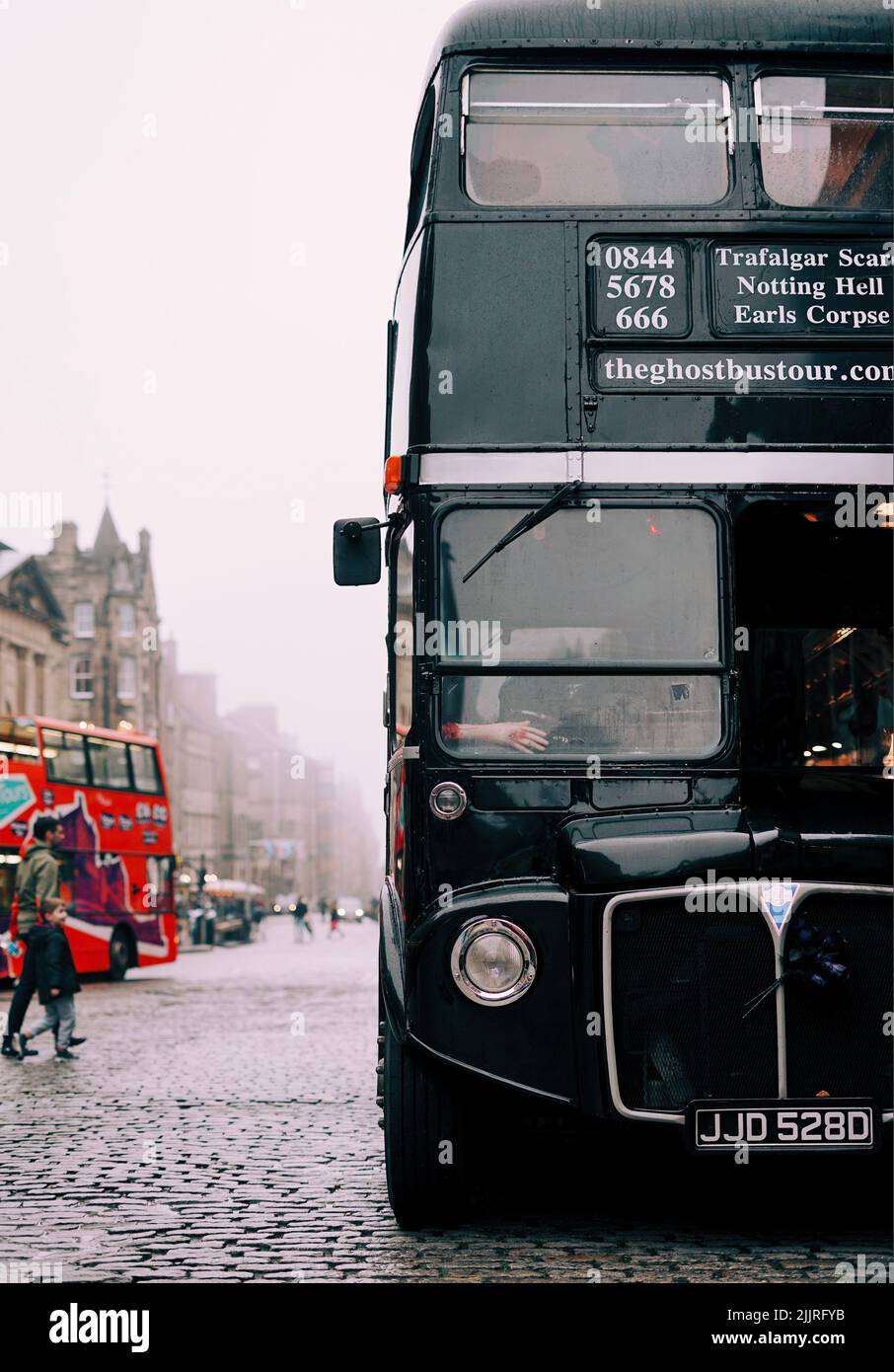 A vertical shot of big trip buses on the paved streets of Edinburgh ...