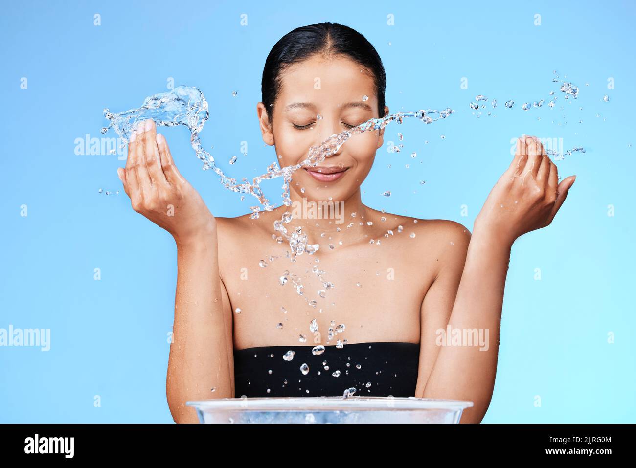 Be you, recklessly. a beautiful young woman splashing water on her face ...
