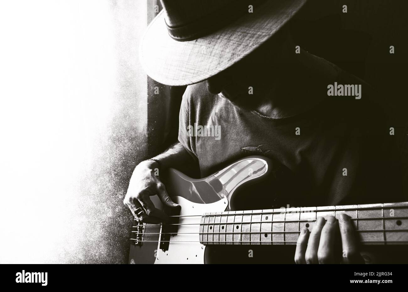 As aesthetic grayscale of a male holding a chord on the bass guitar ...