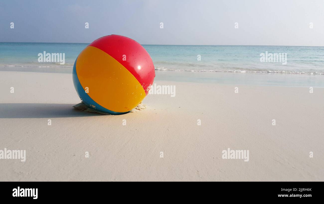 A colorful ball on a sandy beach Stock Photo - Alamy