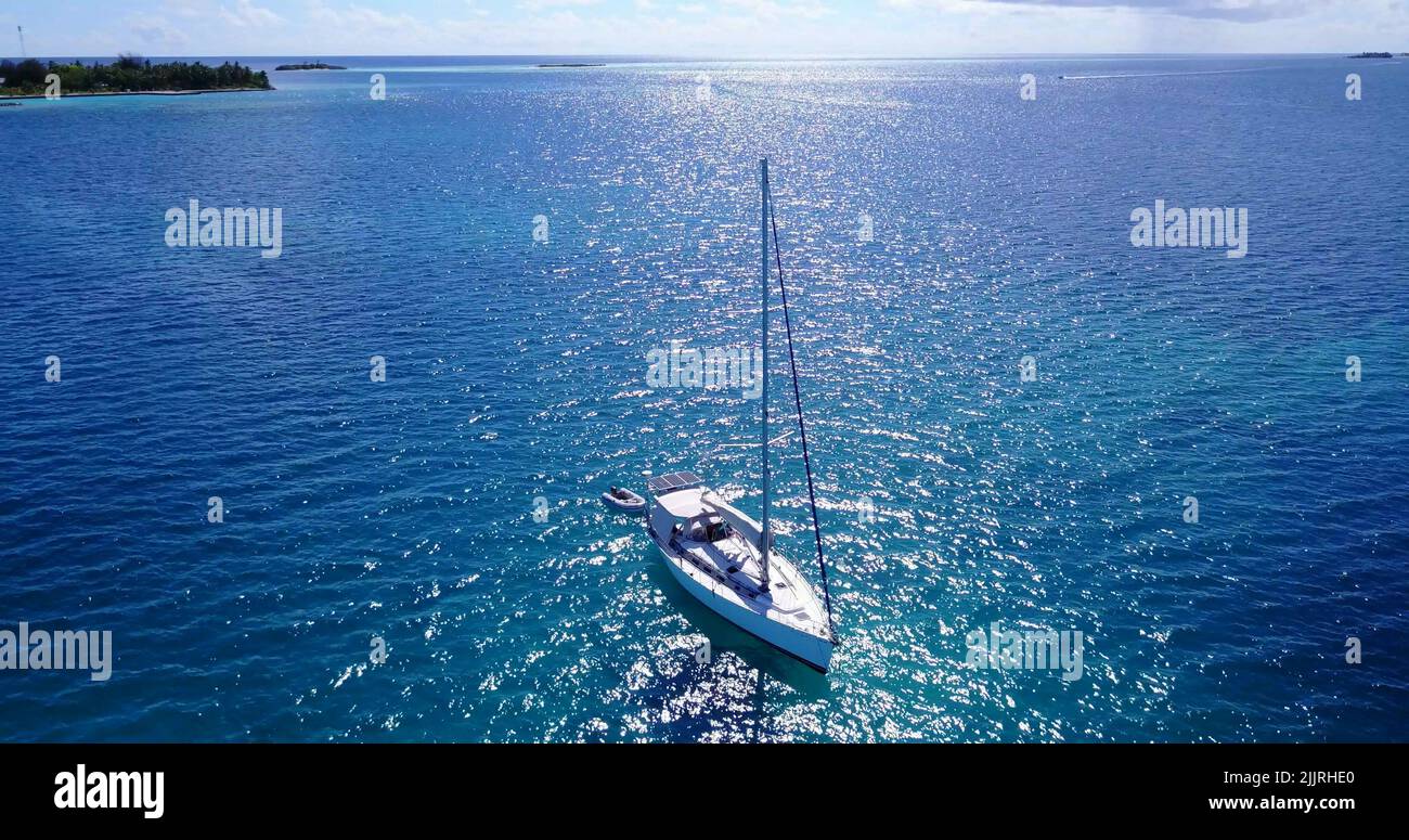 An aerial drone shot of a lonely white boat in the middle of the ocean ...