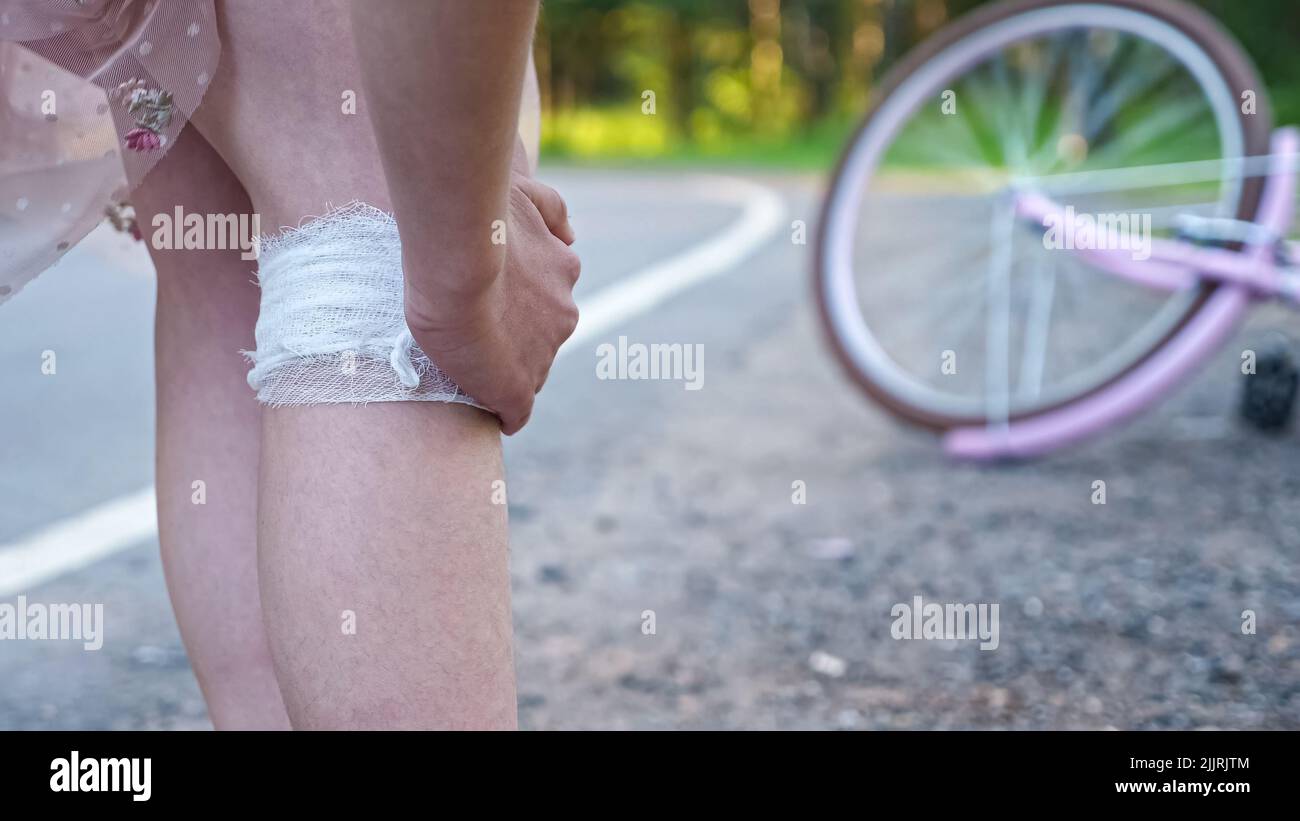 Teenager has injury on leg after falling from bicycle Stock Photo - Alamy