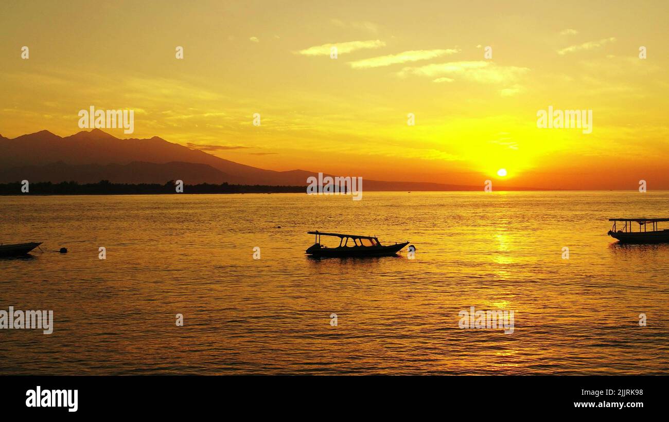 A beautiful view of boats in a sea under the clear sky during sunset in ...