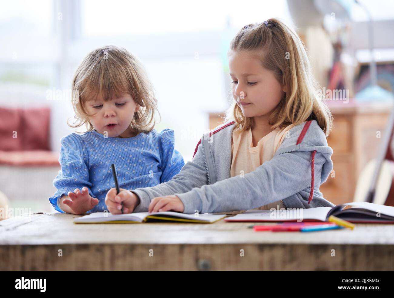 Your big sister can help. two little sisters drawing at home Stock ...