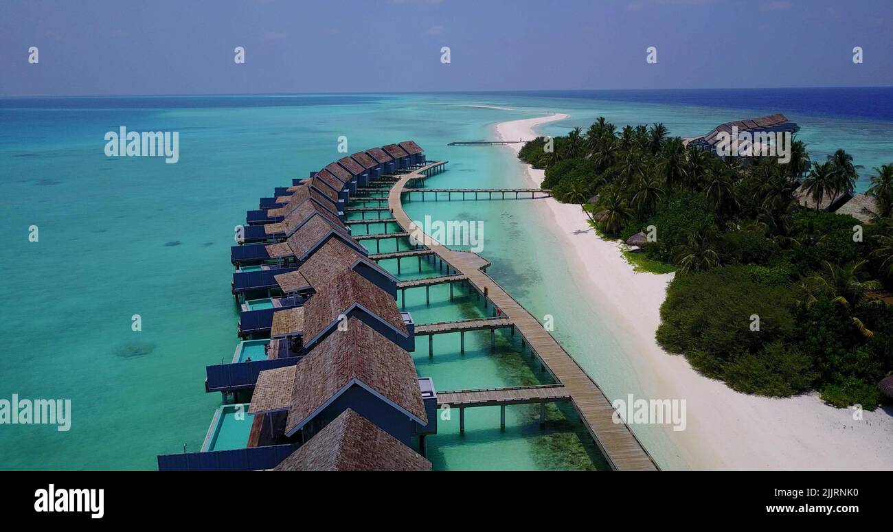 An aerial view of the azure water of the ocean and a green island in ...