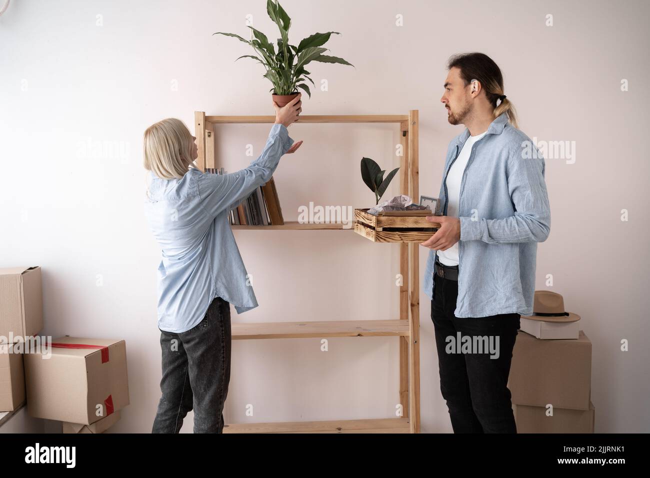 Apartment owners man and women move to a new house, unpack things put ...