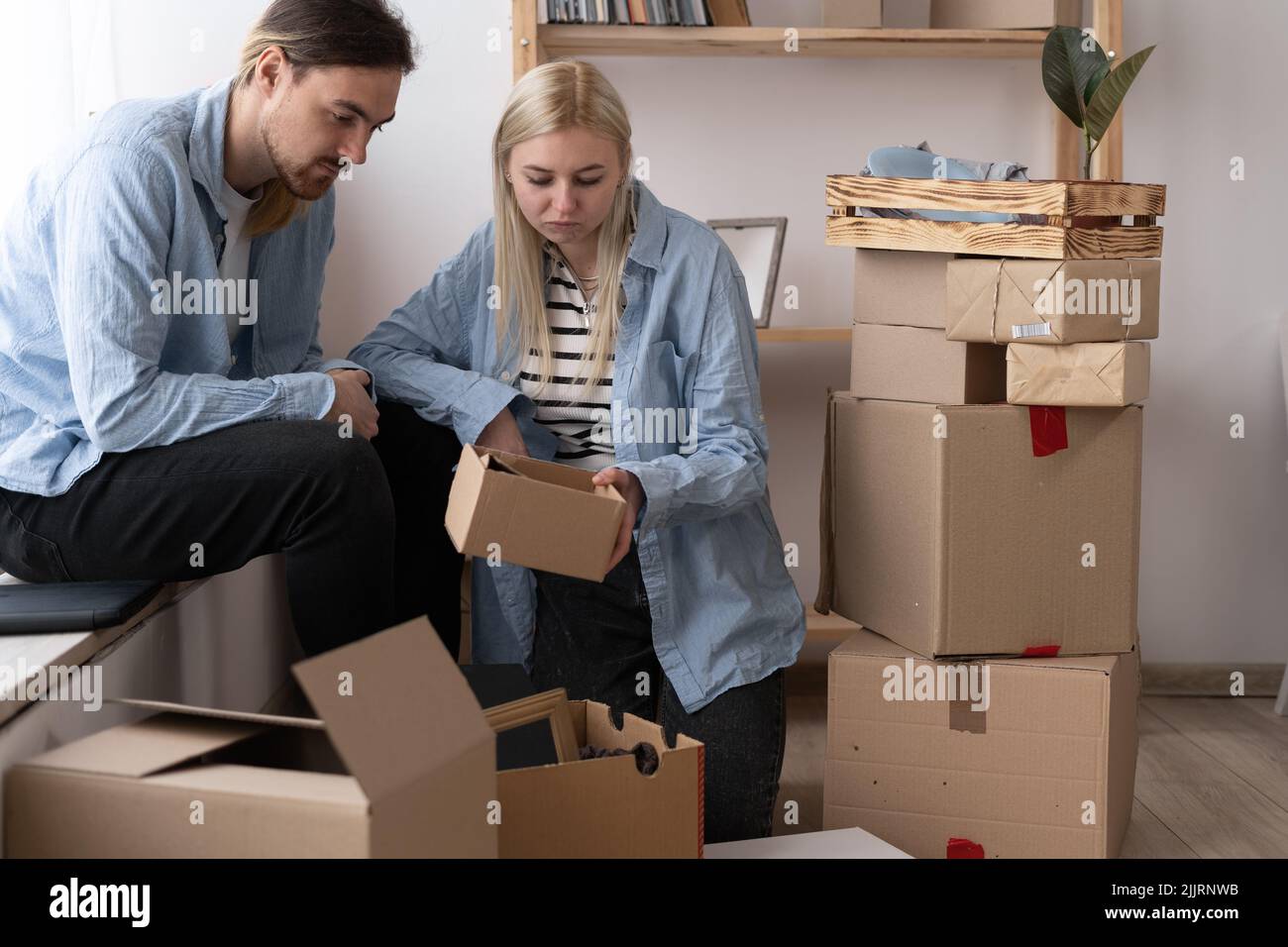 Unhappy woman client dissatisfied by parcel, looking in open cardboard ...