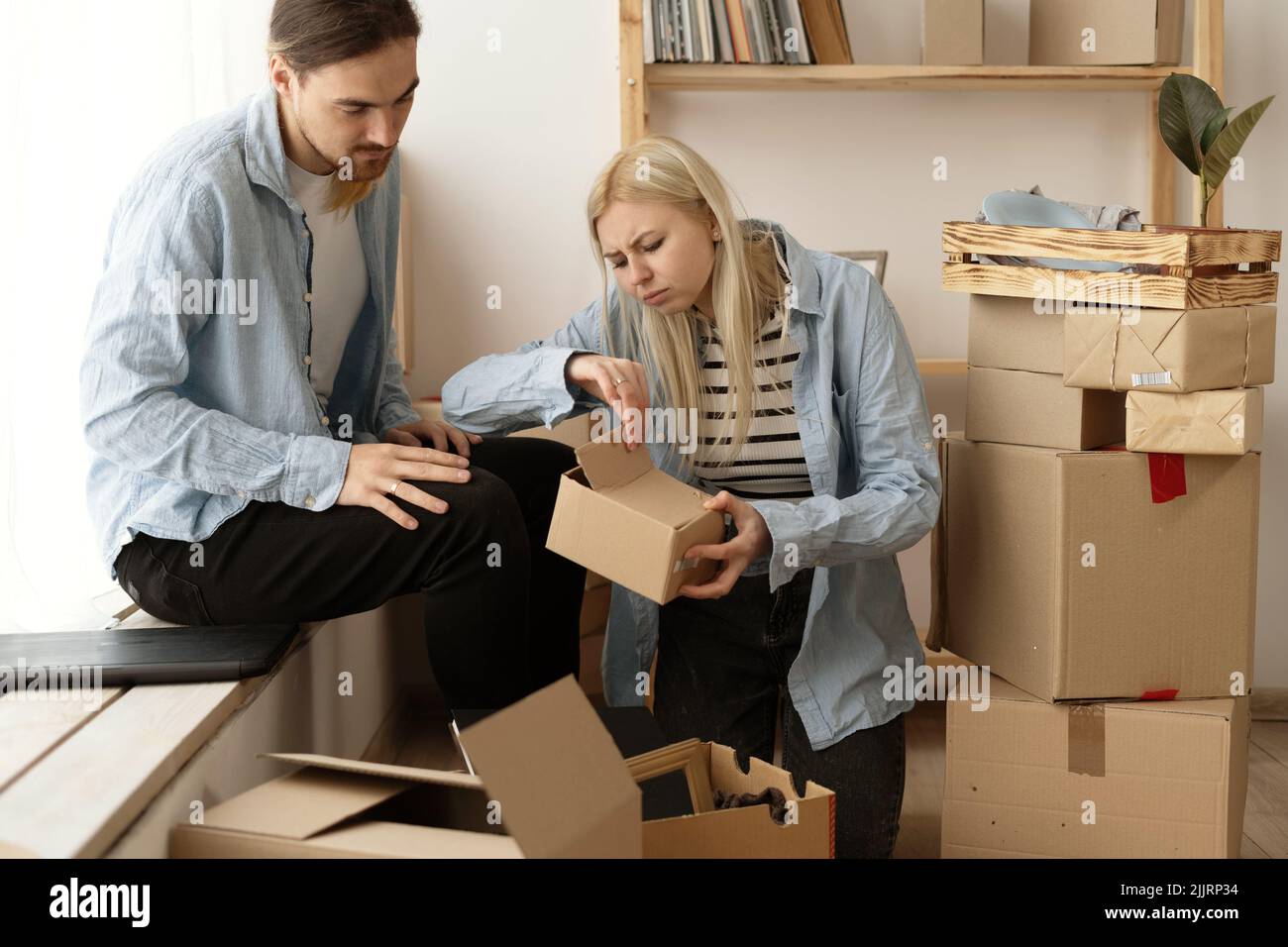 Unhappy woman client dissatisfied by parcel, looking in open cardboard ...