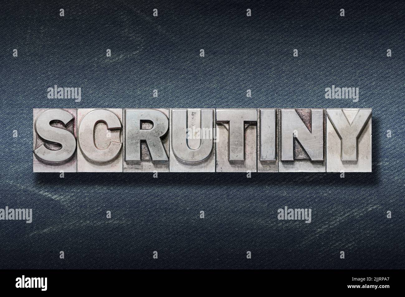 scrutiny word made from metallic letterpress on dark jeans background Stock Photo - Alamy
