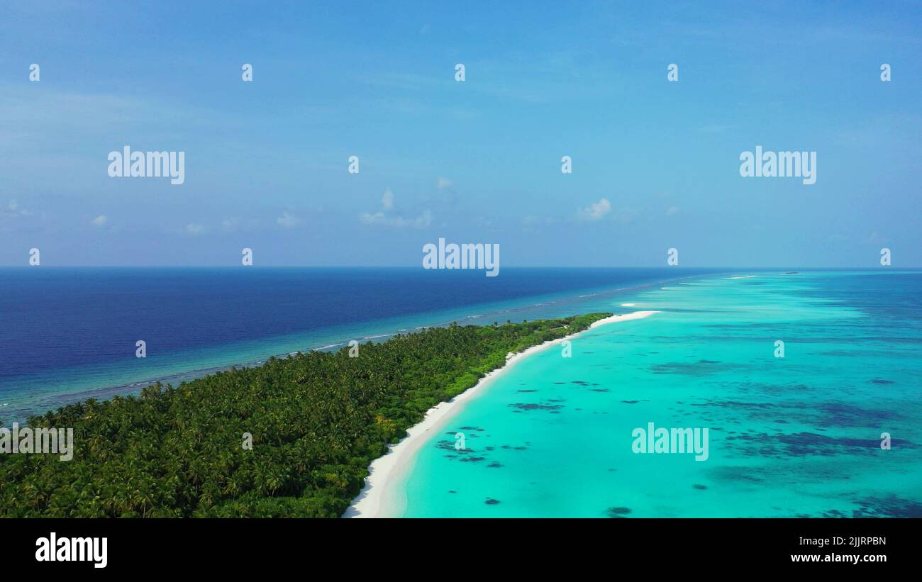 A drone shot of a green island with turquoise and blue water in The ...