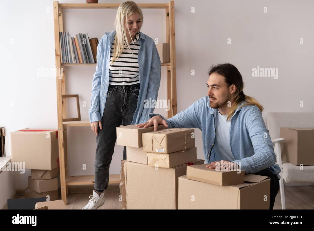 young couple moving to new house around cardboard boxes, moving day ...