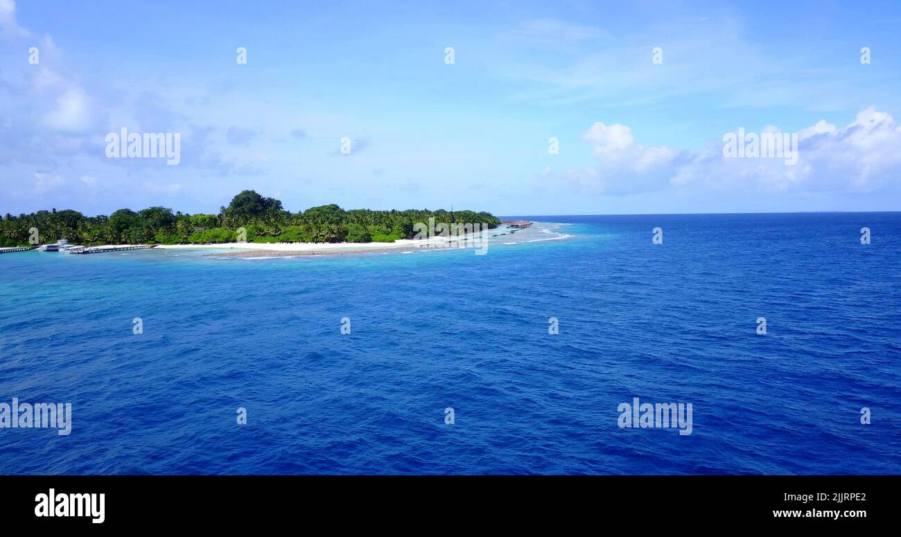 A mesmerizing view of a small green island with the blue sea under ...