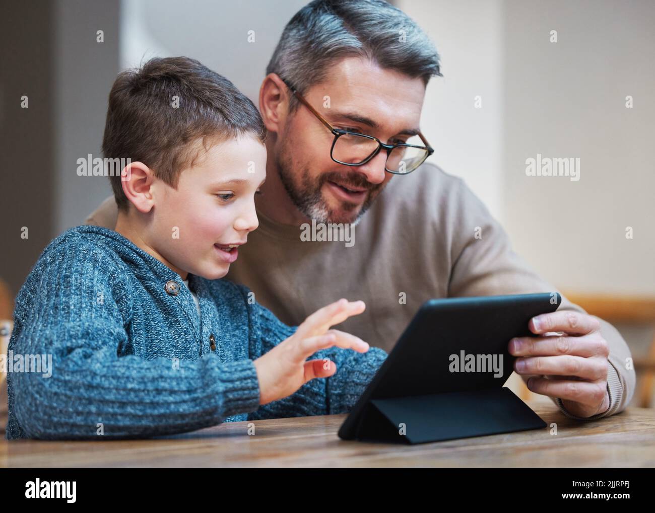 Thank goodness for the miracle of technology. a father and son using a ...