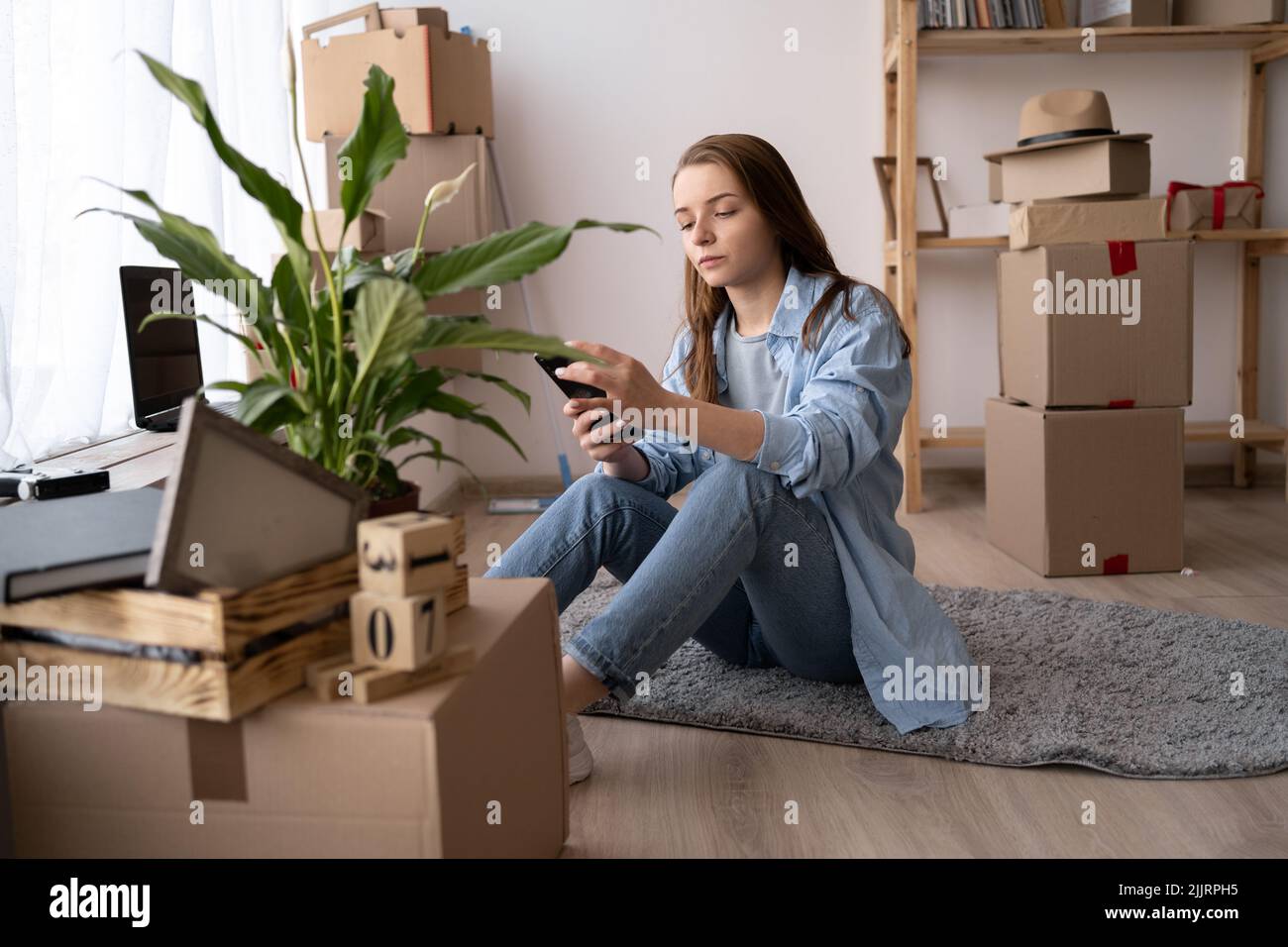 Moving day. Home move out of apartment moving boxes woman using online ...
