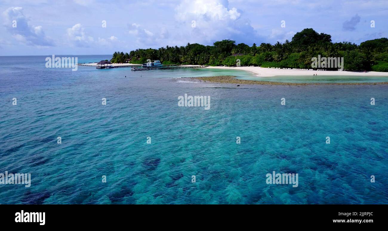 An aerial view of turquoise water with coral reef by an island with ...
