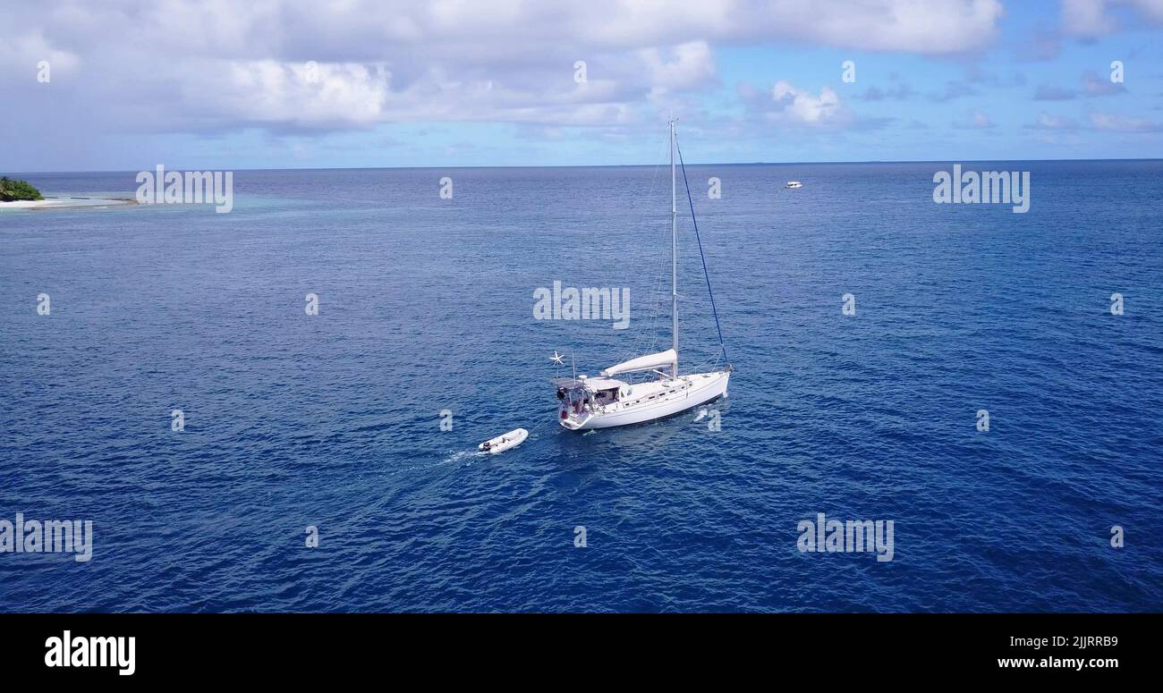 A beautiful shot of a yacht sailing across a deep blue ocean with other ...