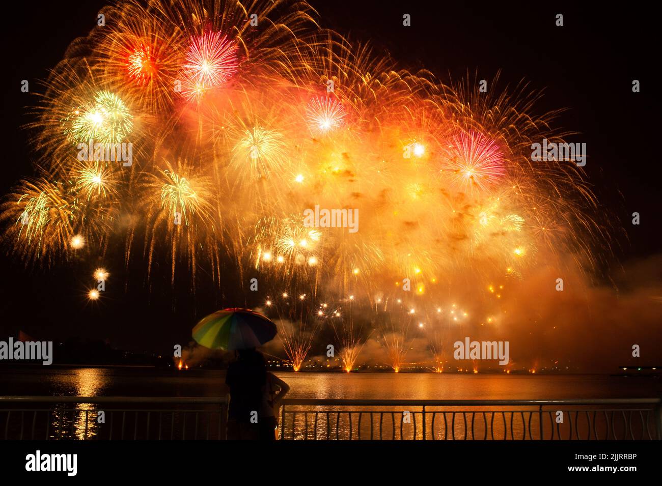 couple with umbrella enjoying firework Stock Photo - Alamy