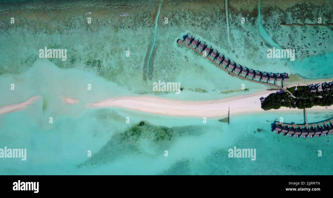 An aerial top view of the blue transparent seascape and a small island ...